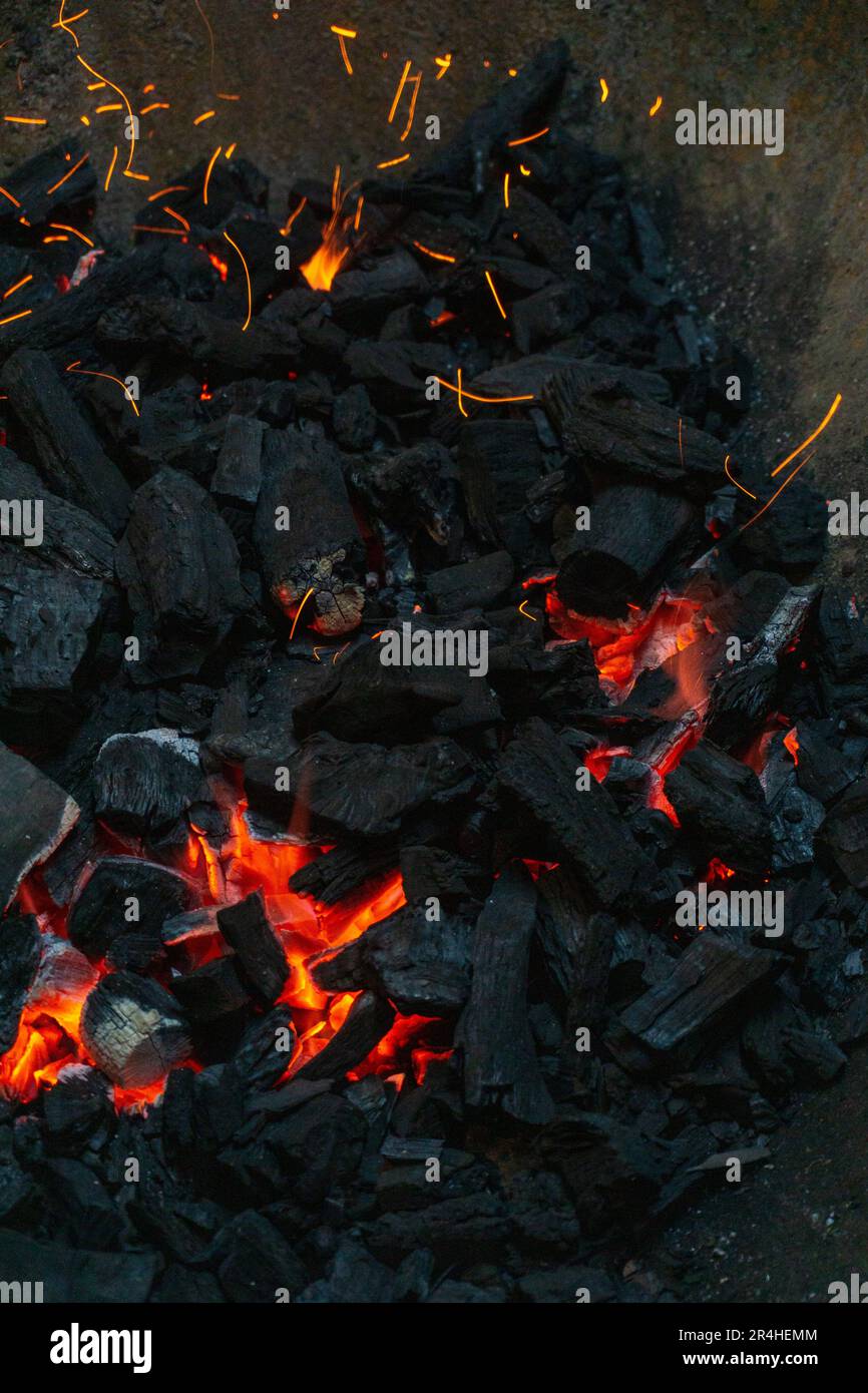 Coals with sparks in a huge old metal grill background Stock Photo - Alamy