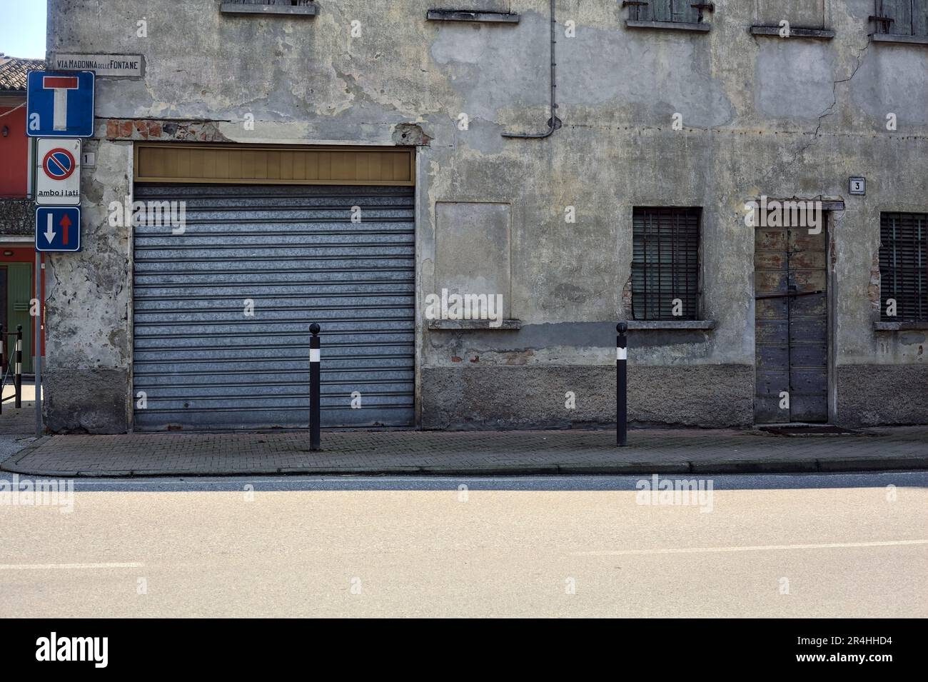 Crossroads between an alley and a road with a closed shop in the corner ...