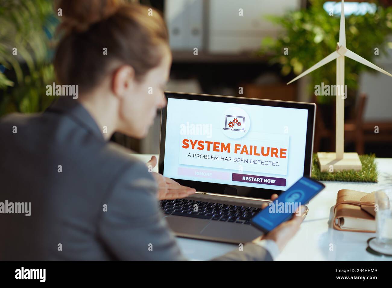 Seen from behind modern female with laptop and smartphone having data ...