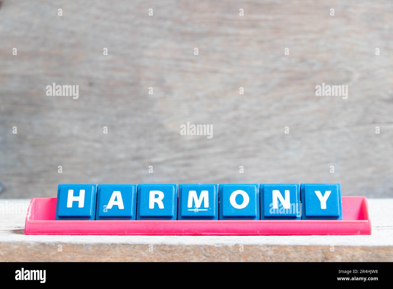Tile alphabet letter with word harmony in red color rack on wood ...