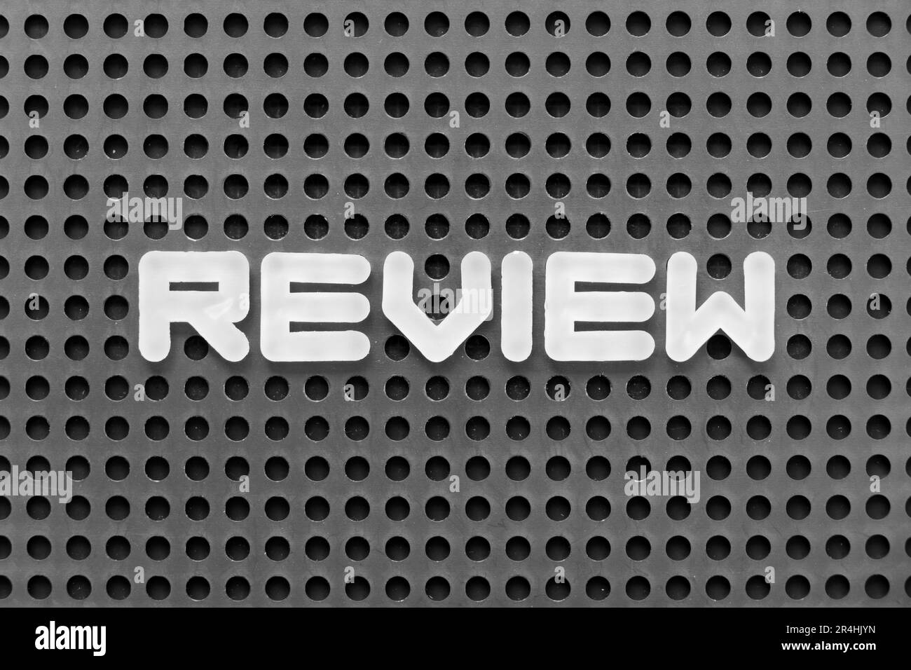 White alphabet letter in word review on black pegboard background Stock ...