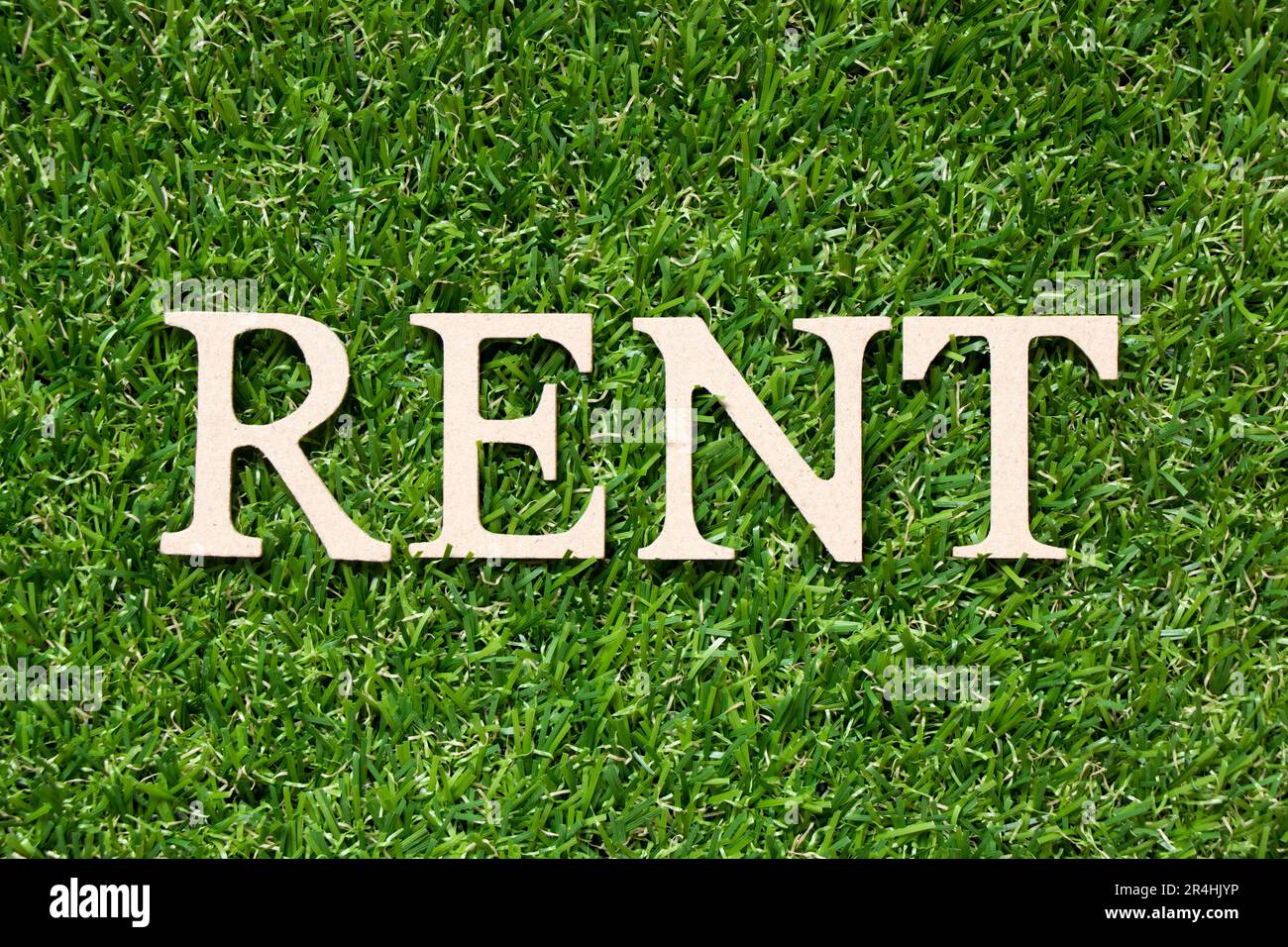 Wood alphabet letter in word rent on artificial green grass background ...