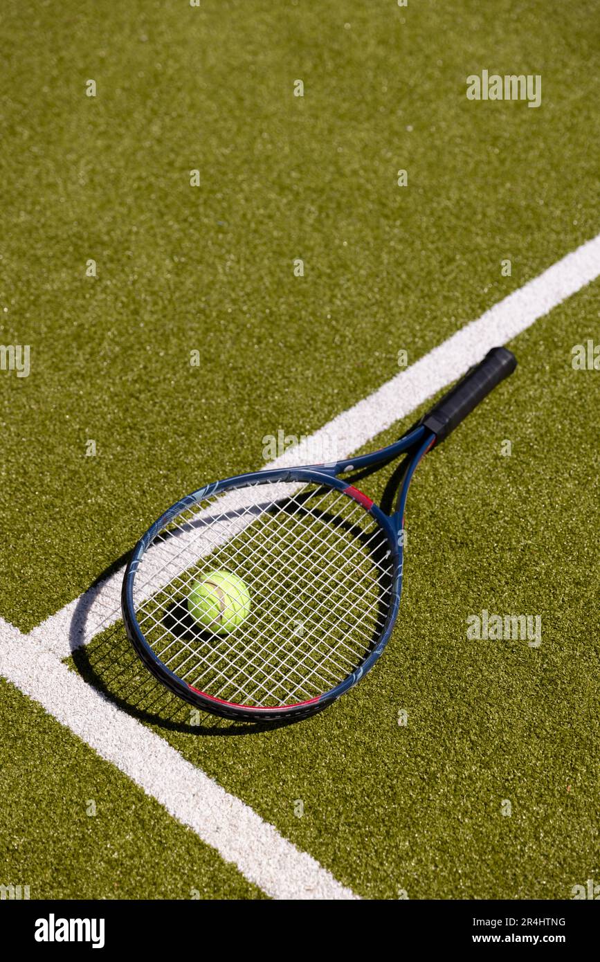 High angle view of tennis racket and ball by marking on grassy land at ...