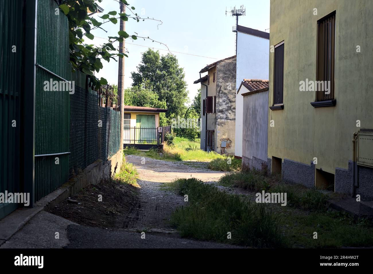 Covered alley between buildings that leads to a path next to a field on ...