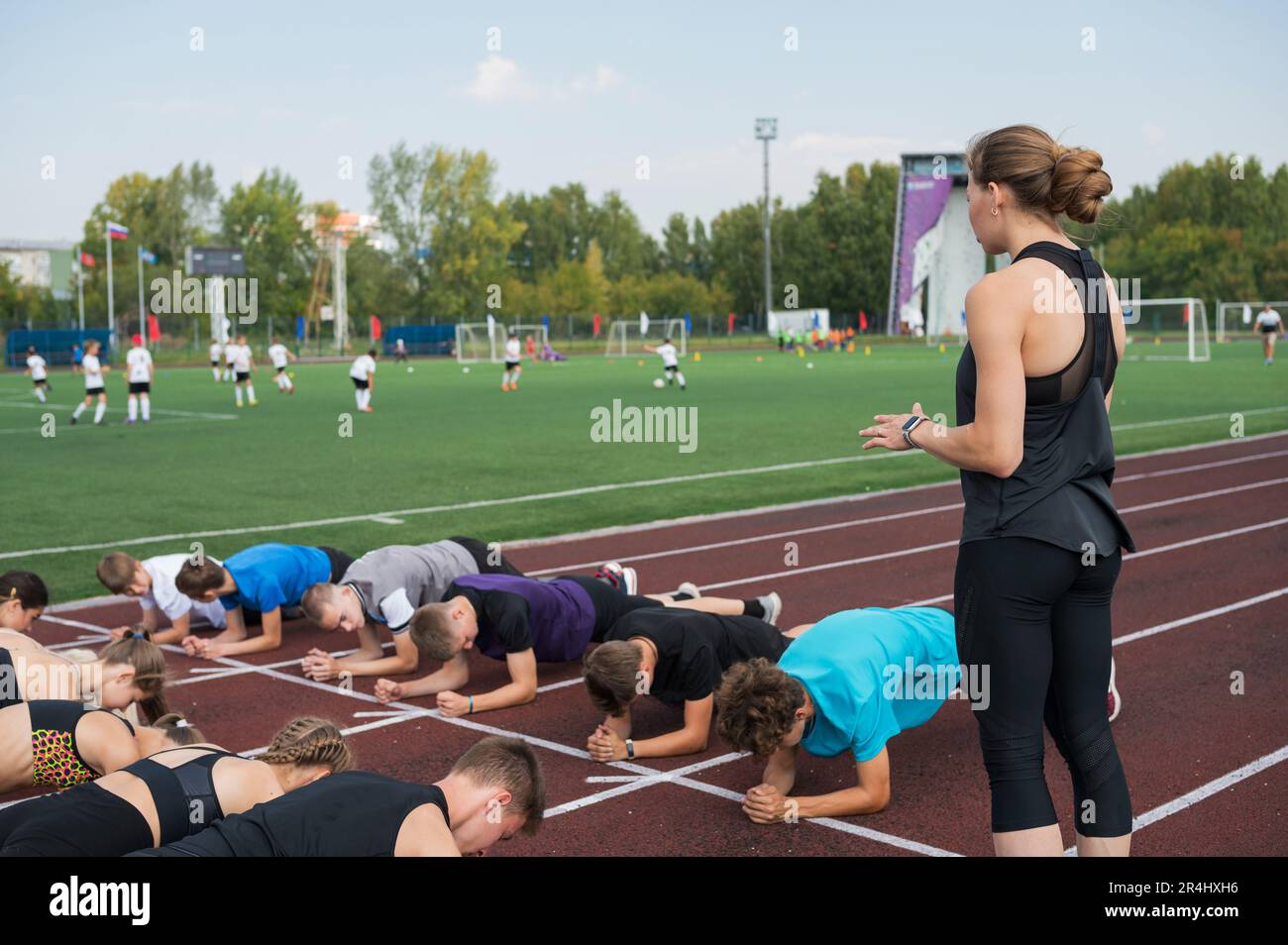 Female coach and group of children conducts a training session at the ...