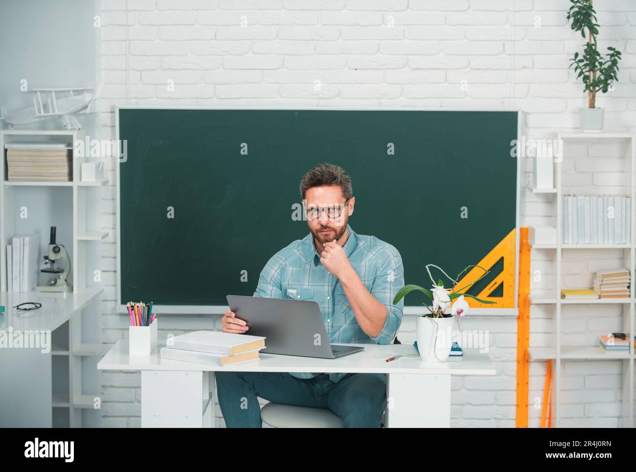 Portrait of male teacher teaching line of high school students with ...