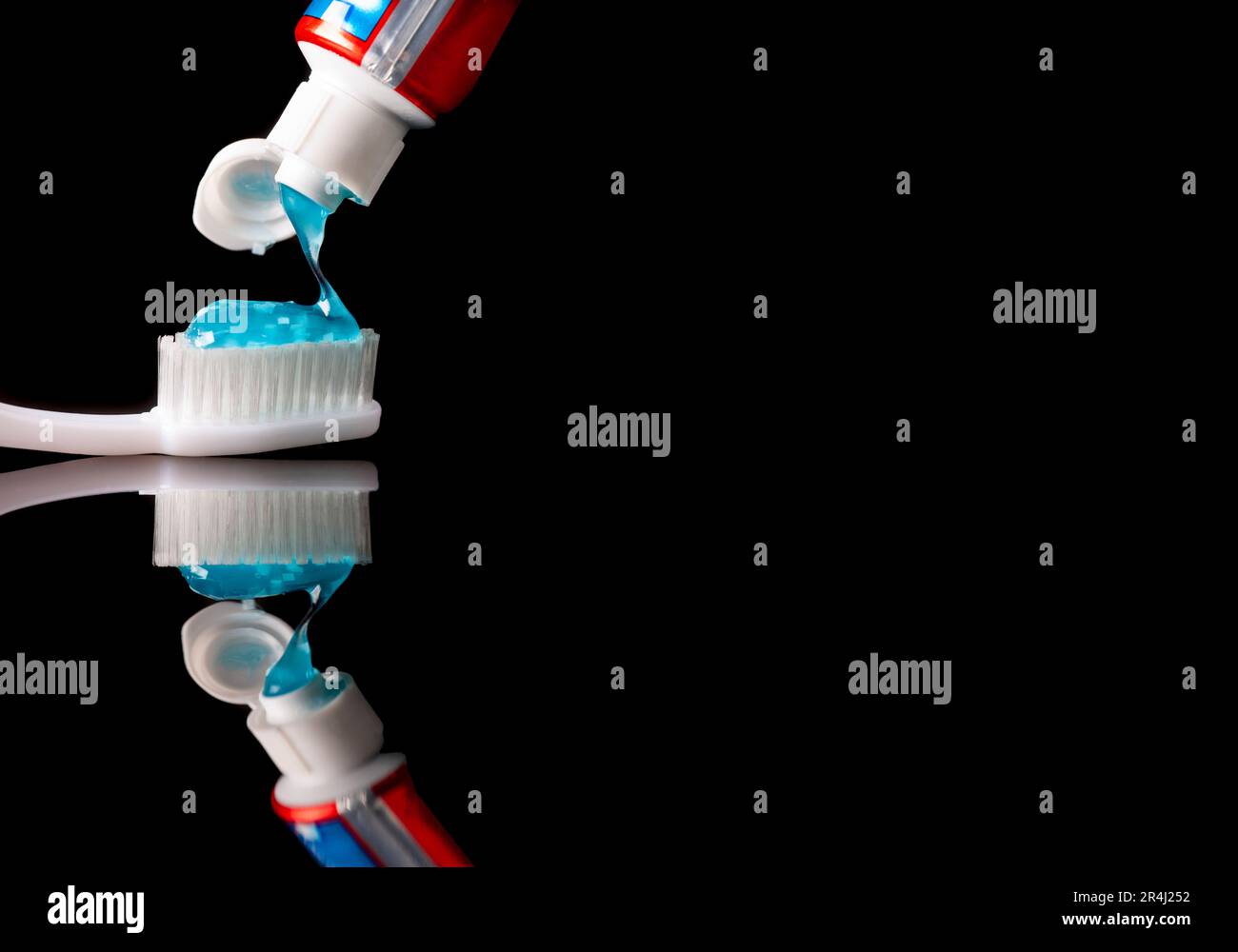 oral care, side view blue gel squeezing from red tube of toothpaste or ...