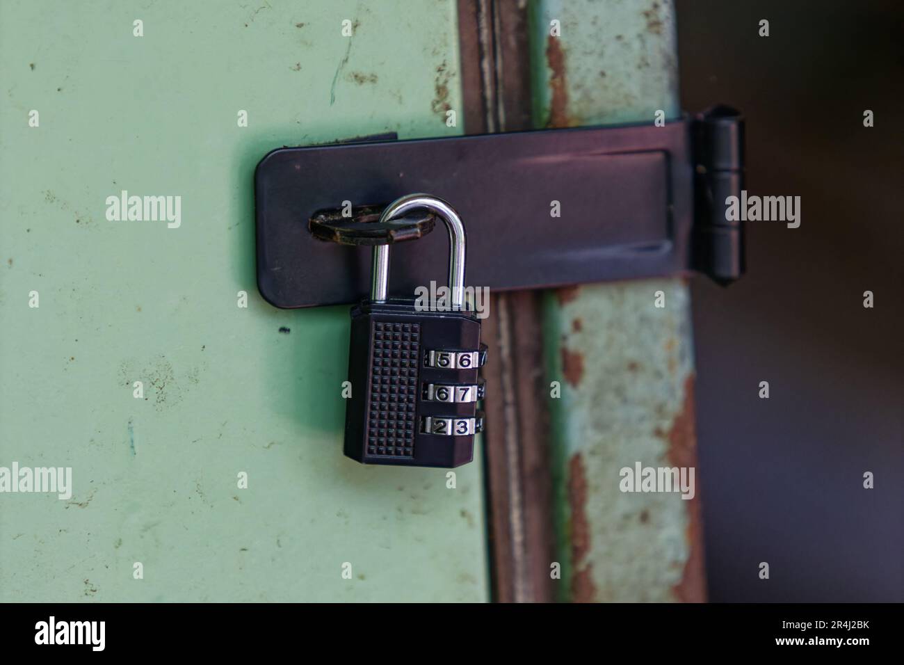 combination lock fastened a old rusty door with style Stock Photo - Alamy