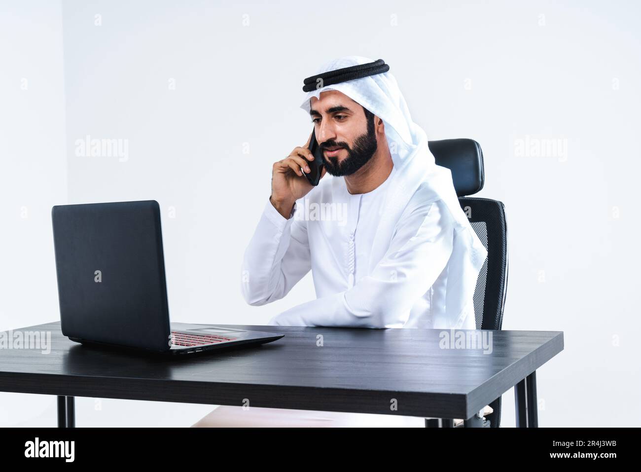Emirate middle-eastern businessman wearing kandora working in the ...