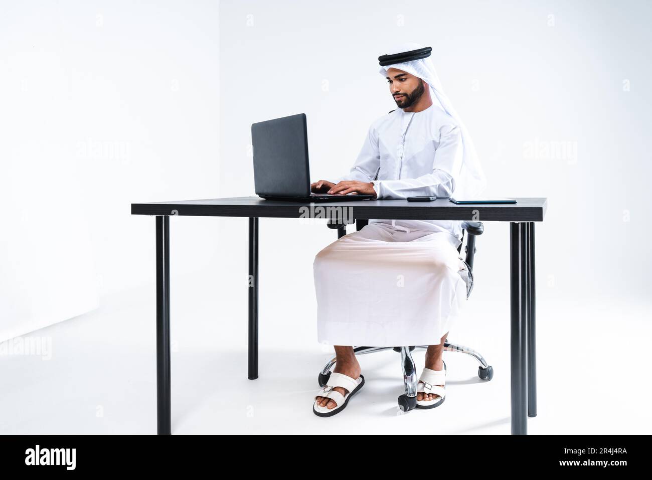 Emirate middle-eastern businessman wearing kandora working in the ...