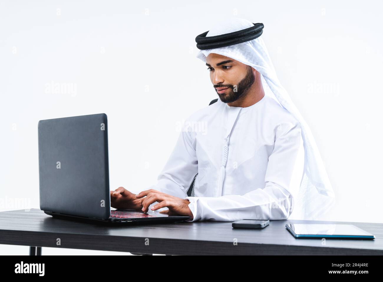 Emirate middle-eastern businessman wearing kandora working in the ...