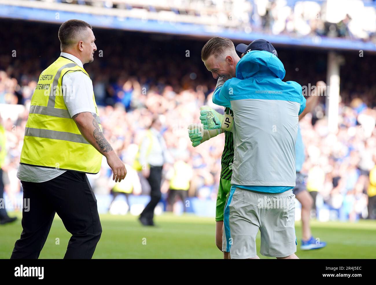 An Everton pitch invader with goalkeeper Jordan Pickford after they ...