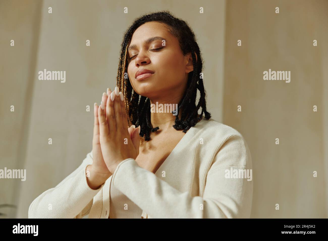 Closeup portrait of African American woman keeping hands in namaste ...