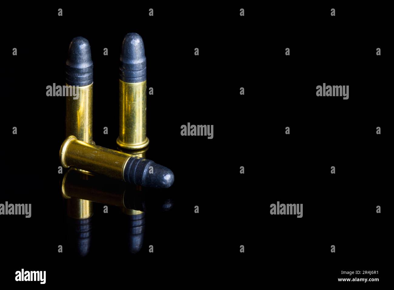 Three small caliber .22 bullets with reflection on a black background ...