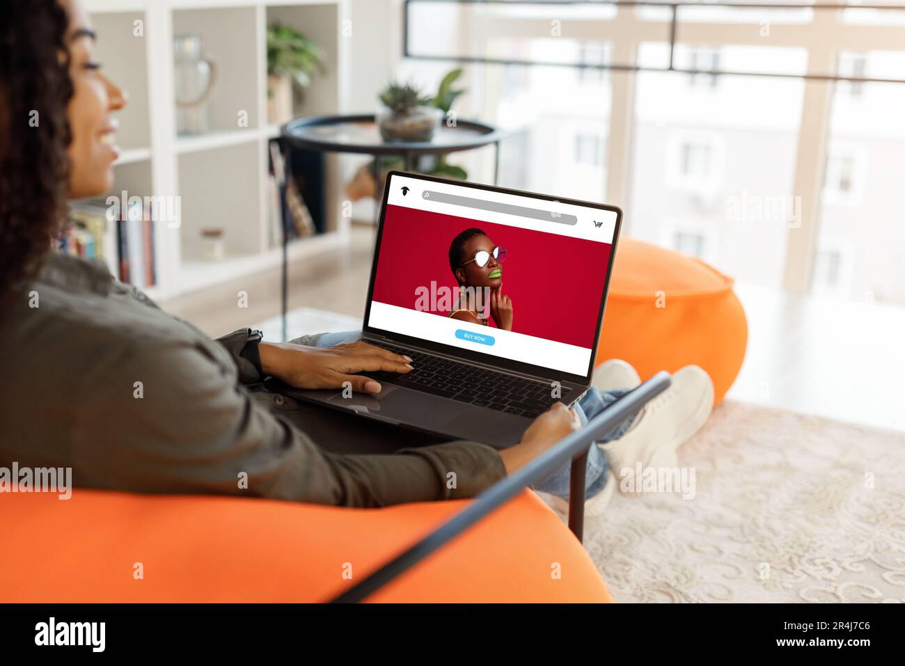 Young smiling african american lady using pc with fashion store on ...
