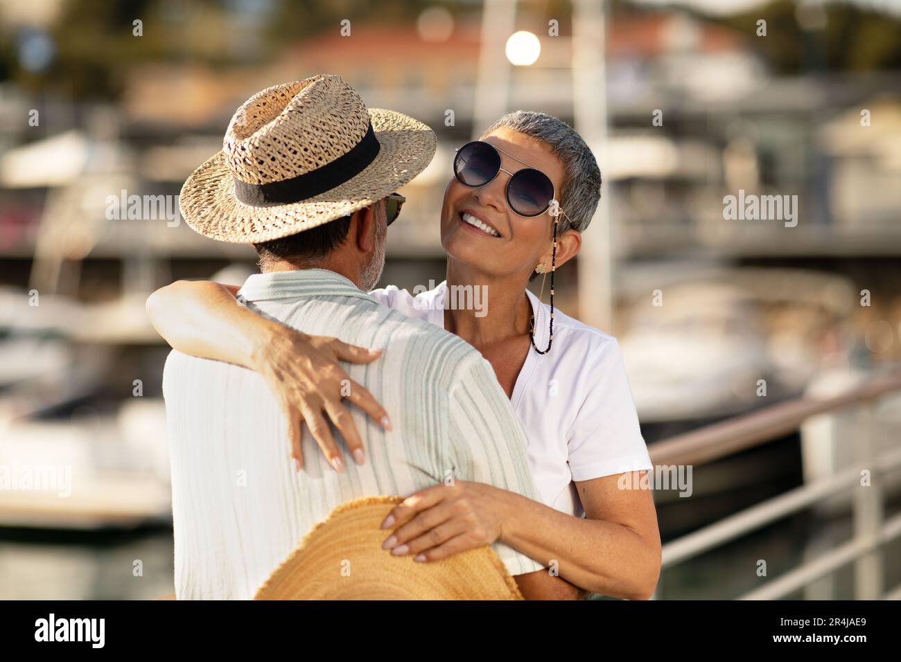 Loving Mature Couple Hugging At Marina Port With Sailboats Outside ...