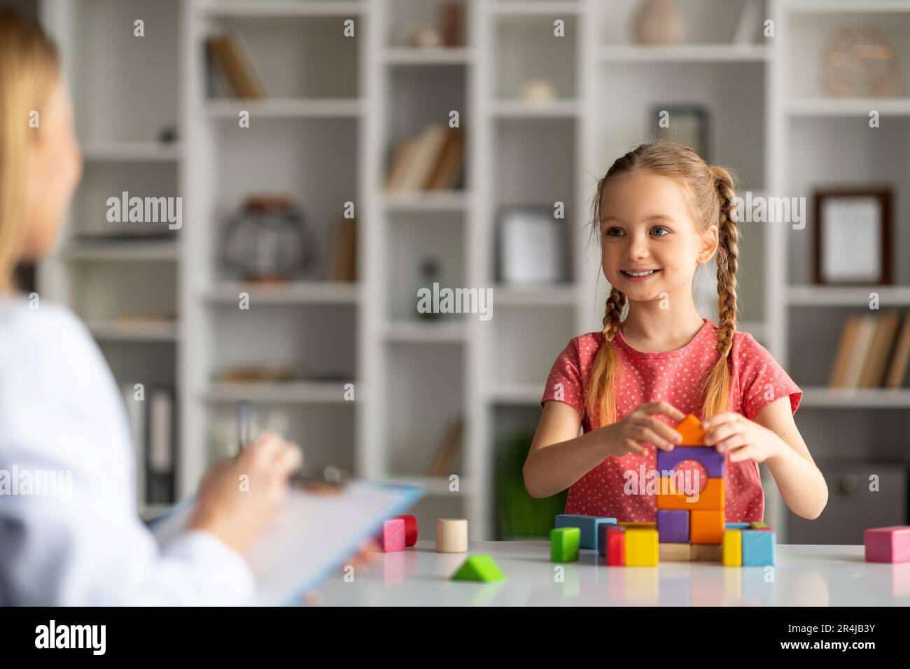 Child development specialist lady having session with cheerful little ...