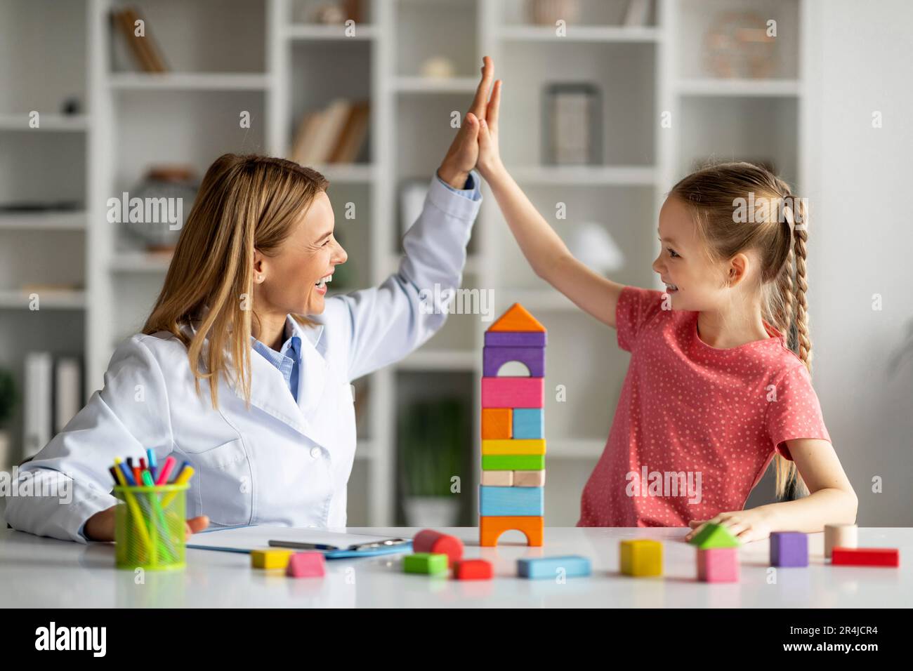 Little Girl Giving High Five To Child Development Specialist ...