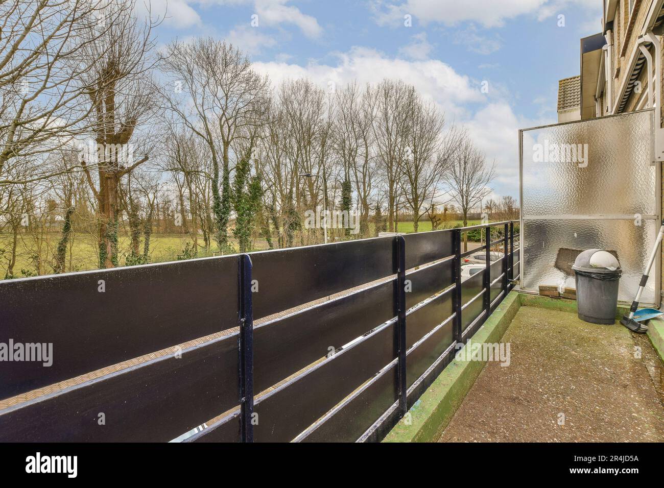 a fenced area with trees in the background and a toilet on the other ...