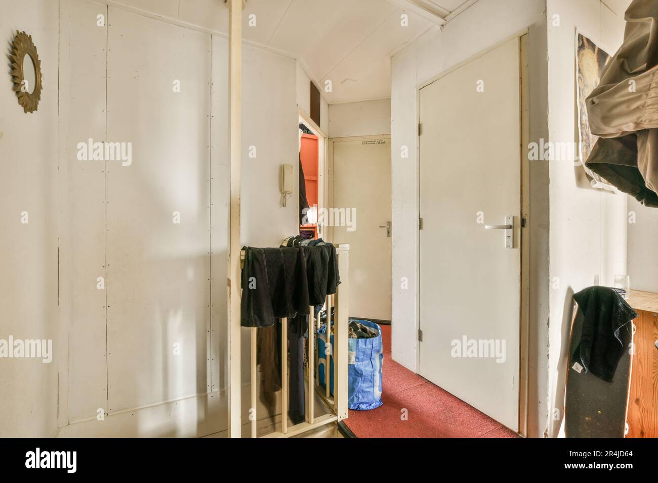 the inside of a room with clothes hanging on the wall and an open door ...