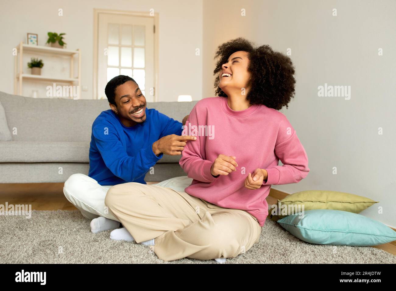 Black Man Tickling Woman Having Fun And Laughing At Home Stock Photo ...