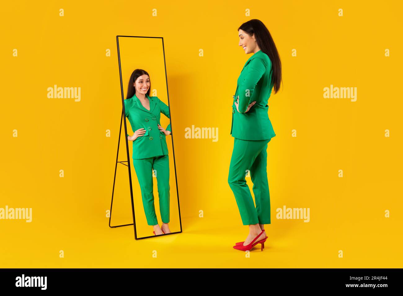 Happy lady wearing long jacket trouser suit and looking at her ...