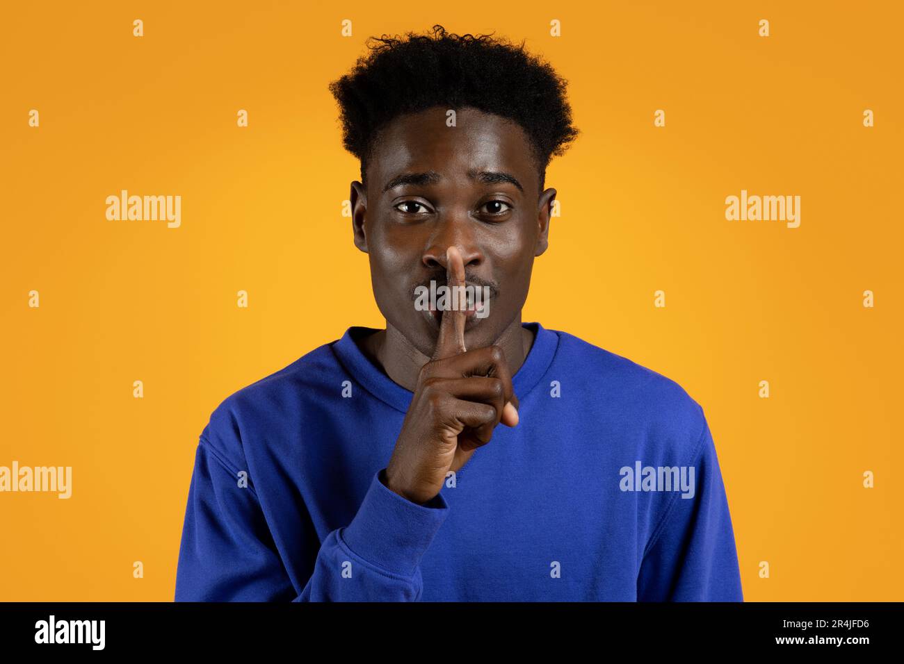 Closeup of black guy showing silence quiet gesture Stock Photo - Alamy
