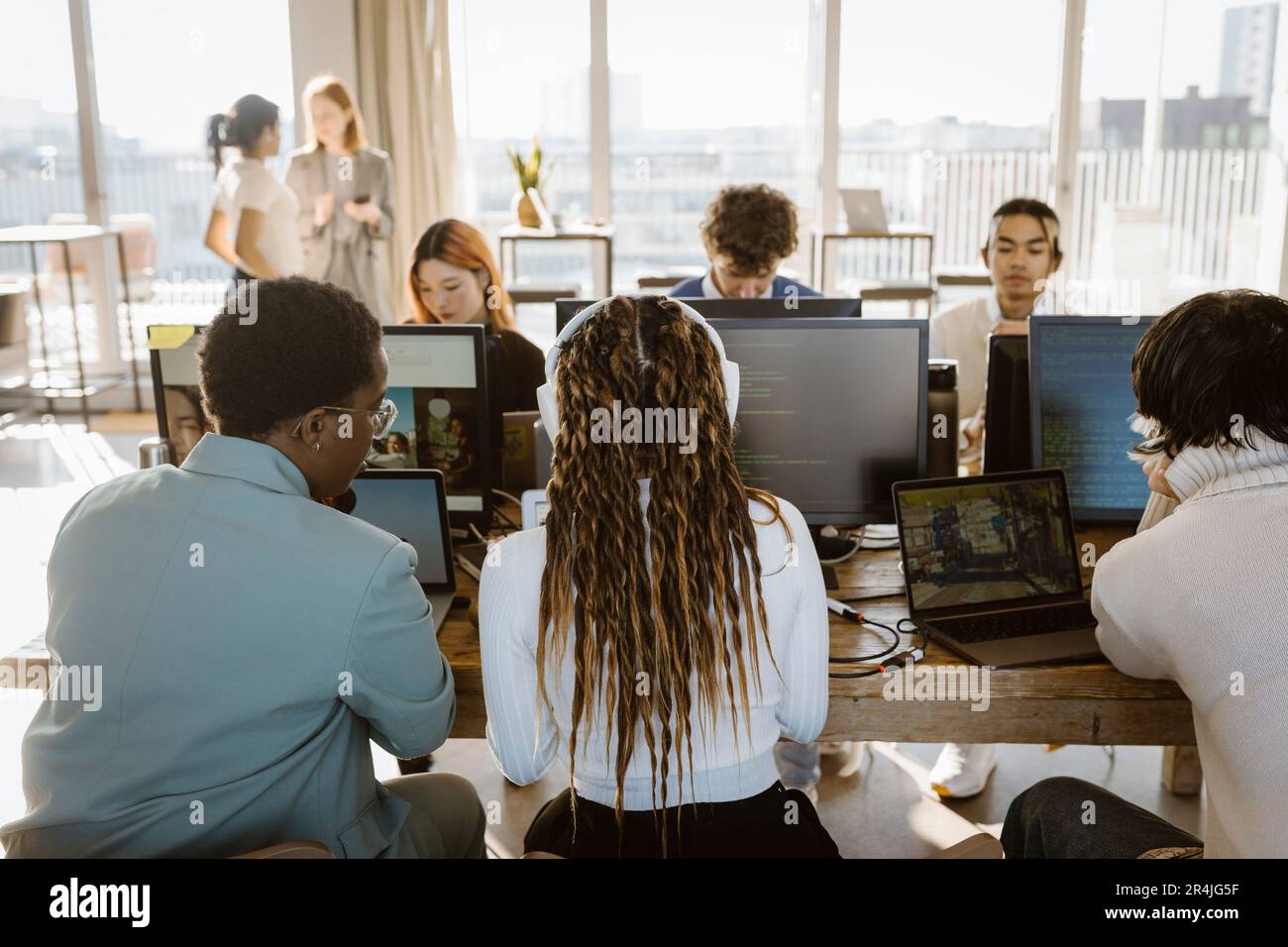 Multiracial male and female programmers working on computer in office ...