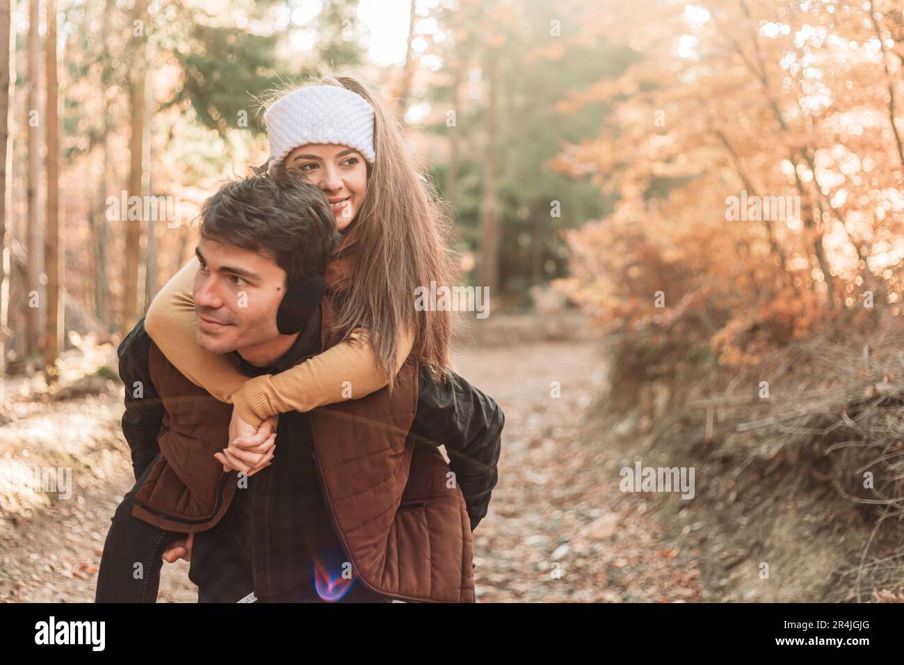 Young romantic couple in the woods. Piggyback riding. Happy together ...