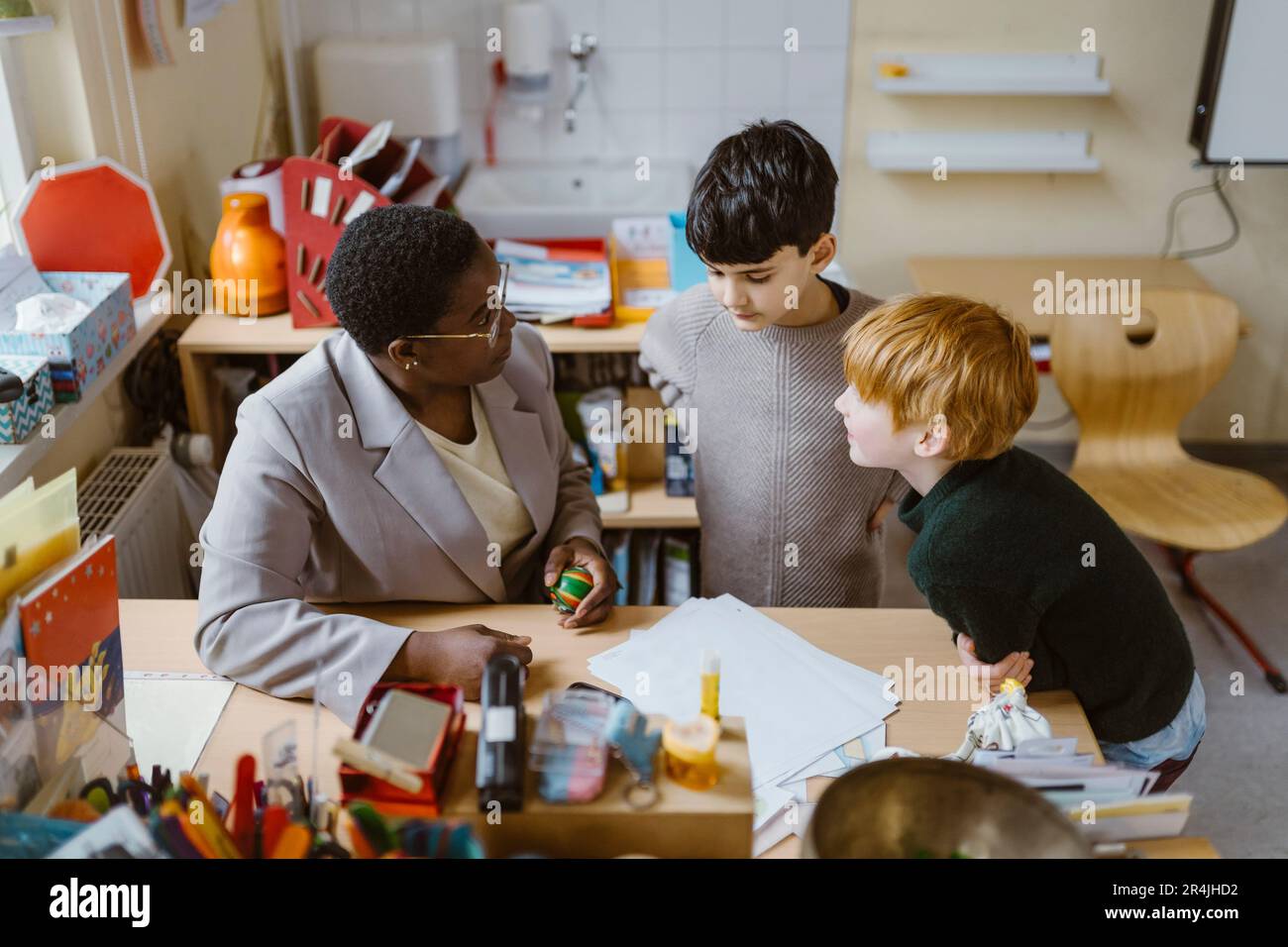 Female teacher explaining schoolboys in classroom Stock Photo - Alamy