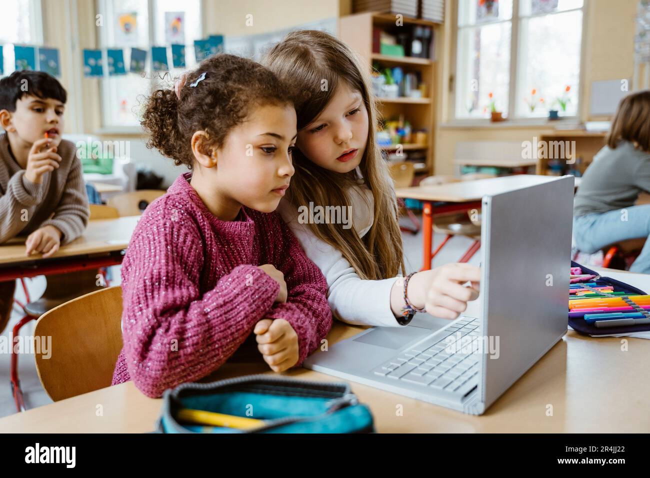 Girls sharing laptop classroom hi-res stock photography and images - Alamy