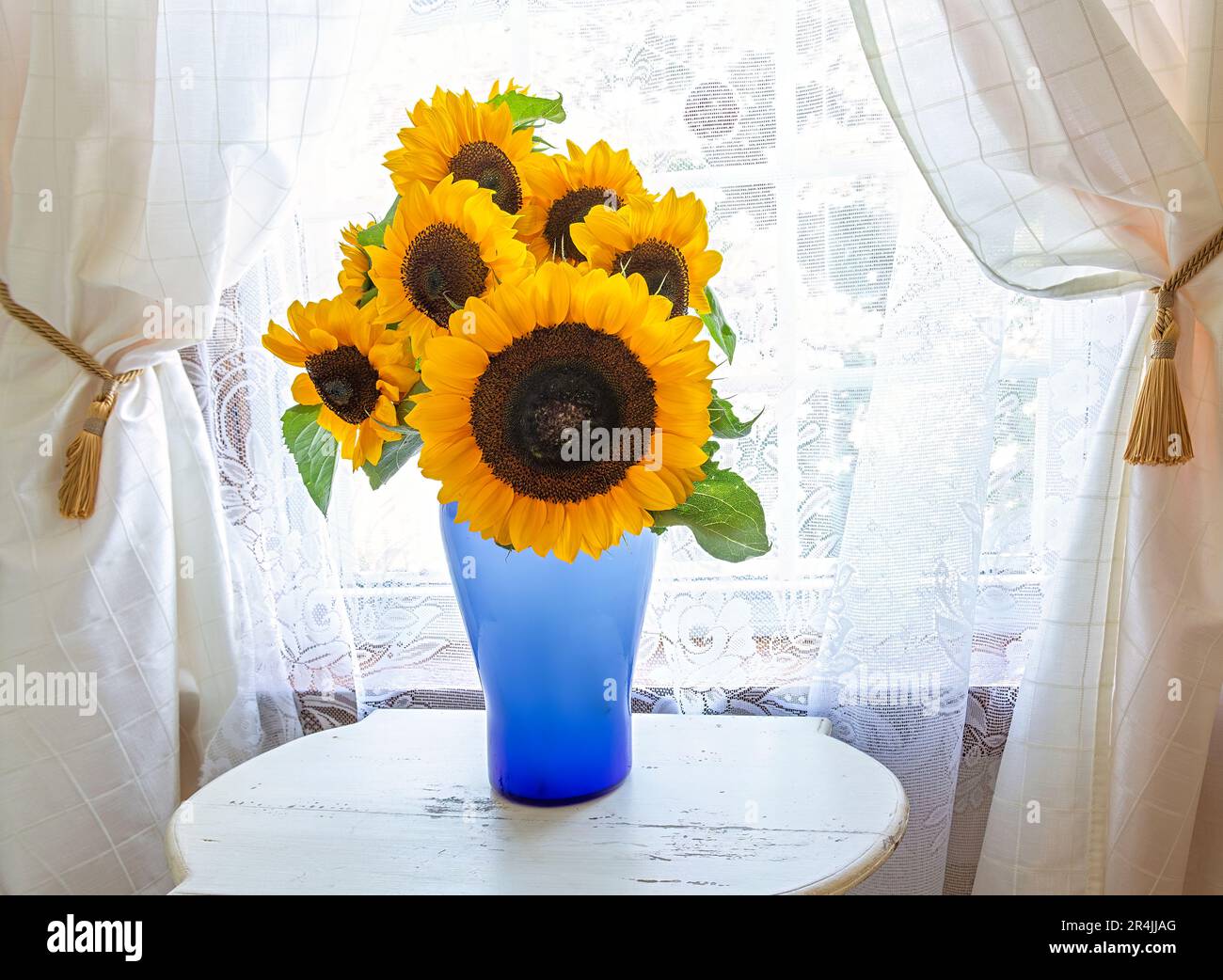 An arrangement of bright sunflowers in a blue vase Stock Photo - Alamy