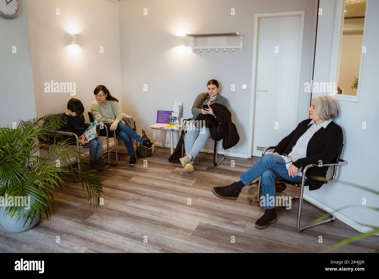 Patients waiting while sitting on chairs at healthcare center Stock ...