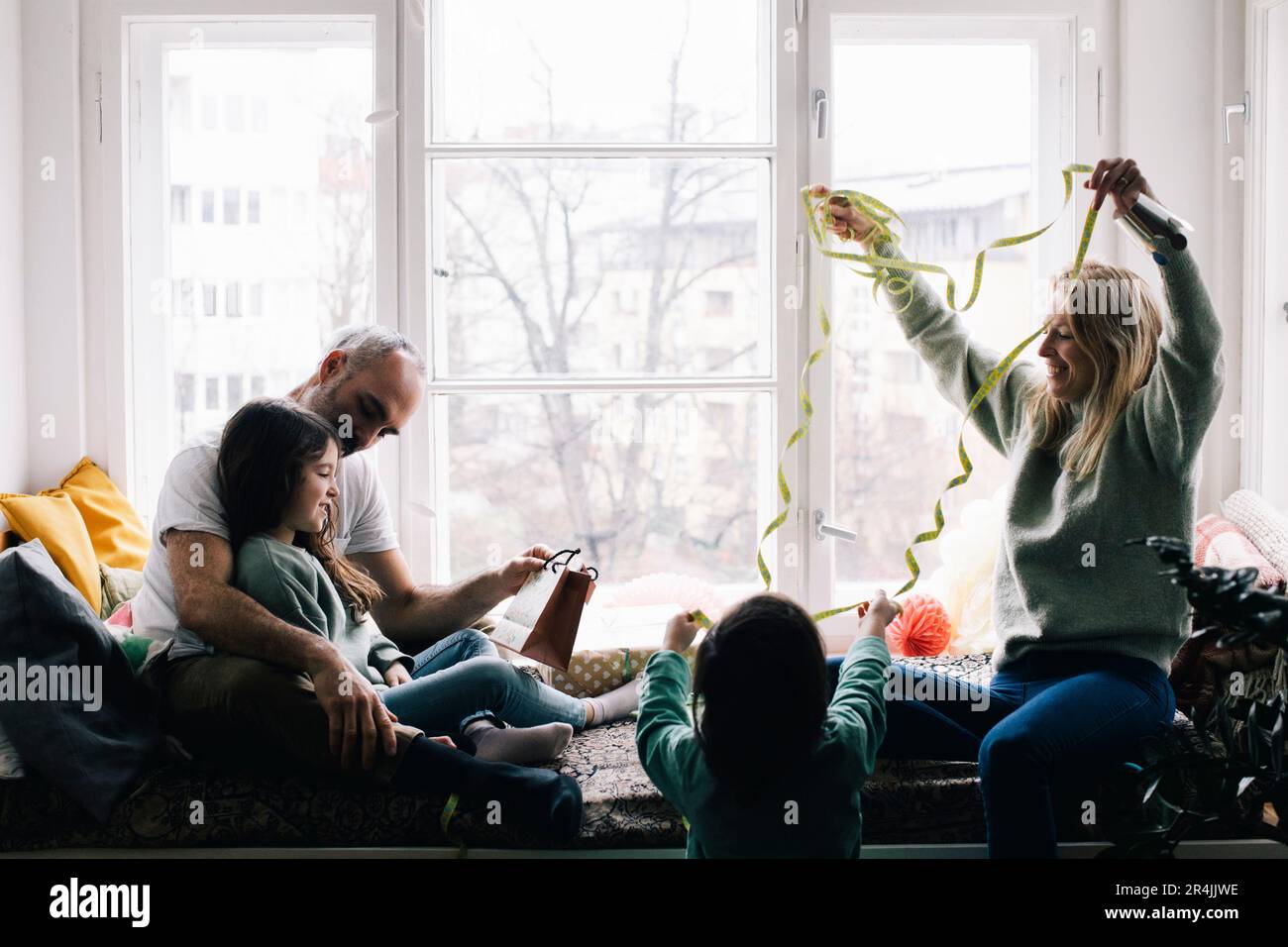 Parents and children decorating for birthday party celebration at home ...