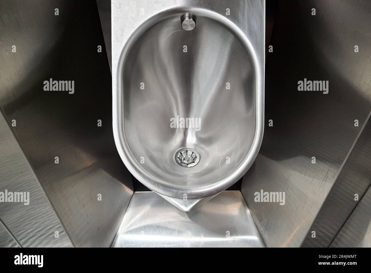 Sanitary metal urinal, toilet bowl in public bathroom with hygienic ...