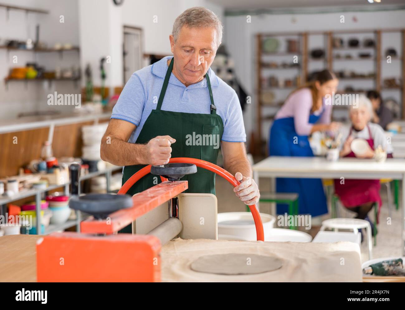 male potter works with machine clay press roller Stock Photo - Alamy