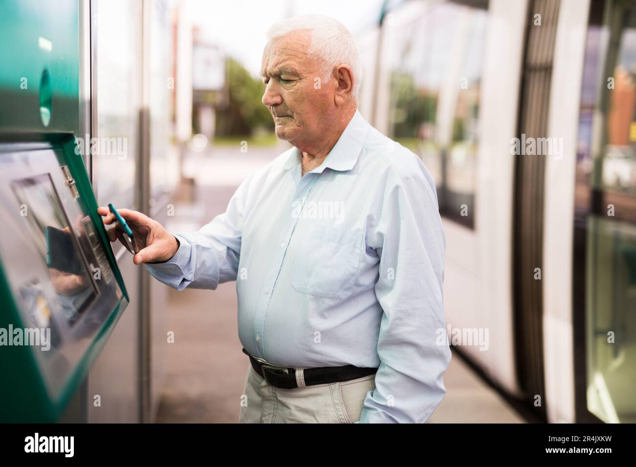 Old man using cash machine with smartphone Stock Photo - Alamy