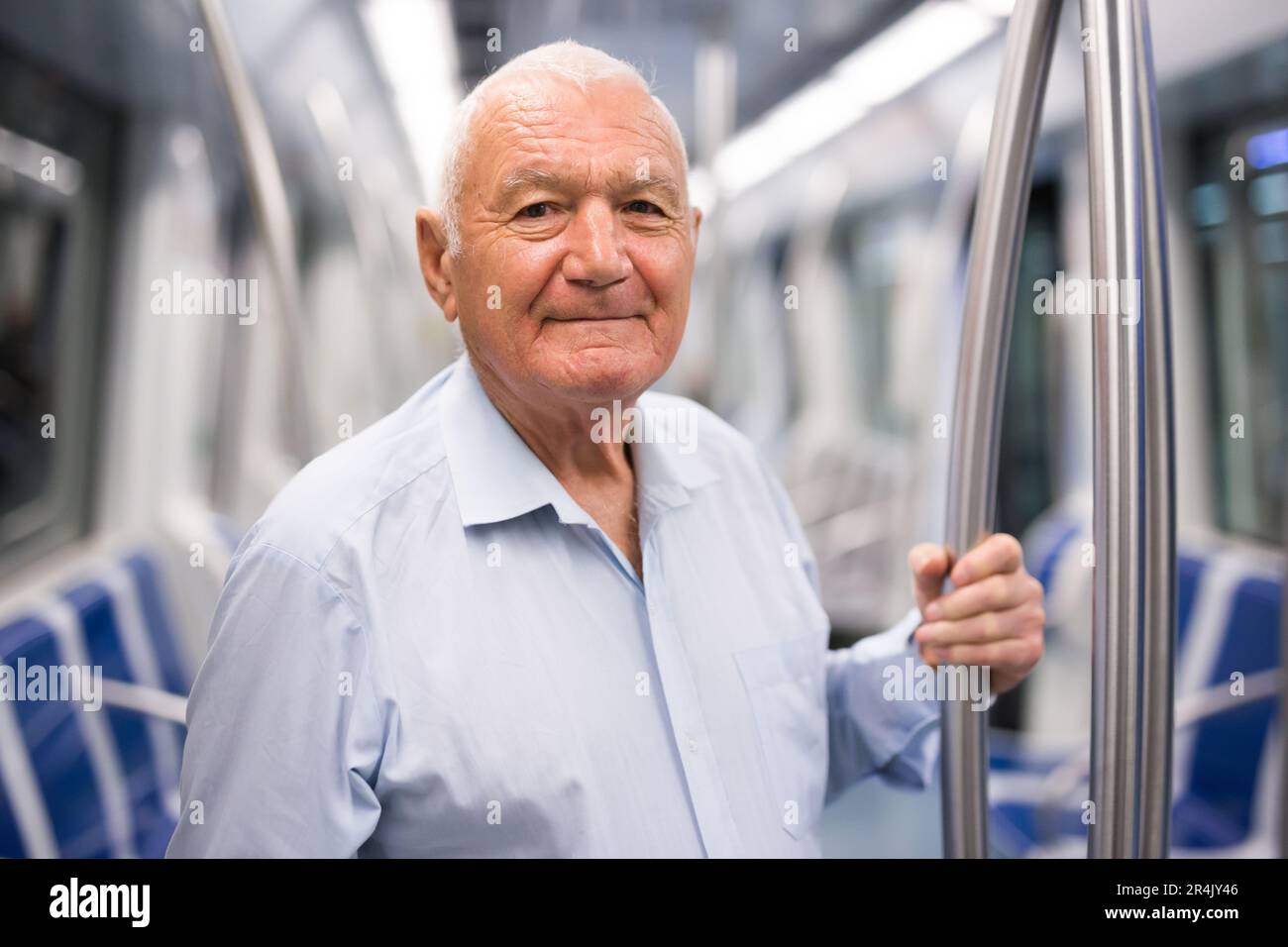 Senior man standing inside subway train Stock Photo - Alamy