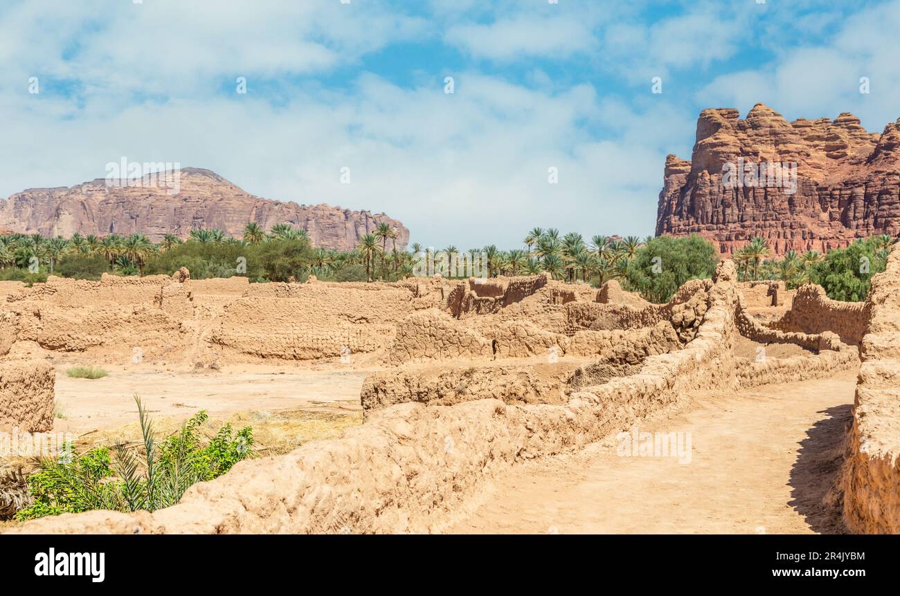 Al Ula ruined old town street with palms and rocks int the background ...