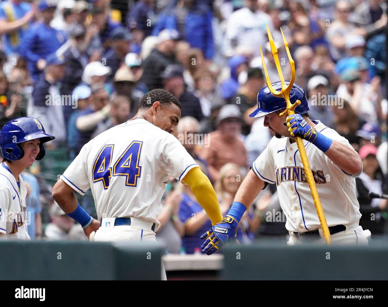 Seattle Mariners designated hitter Cal Raleigh, right, holds a trident ...