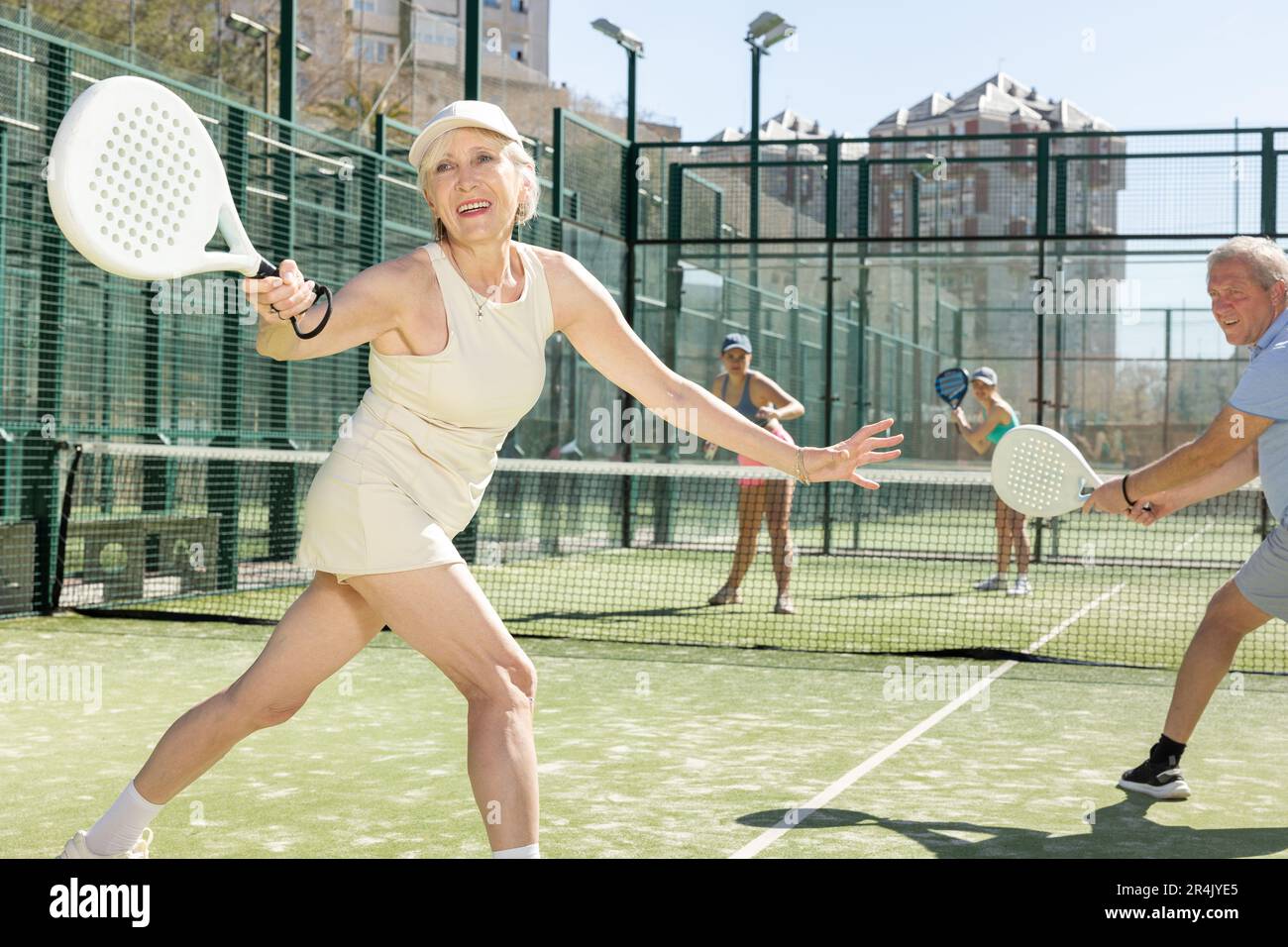 Mature sporty woman playing padel game in court on sunny day Stock ...