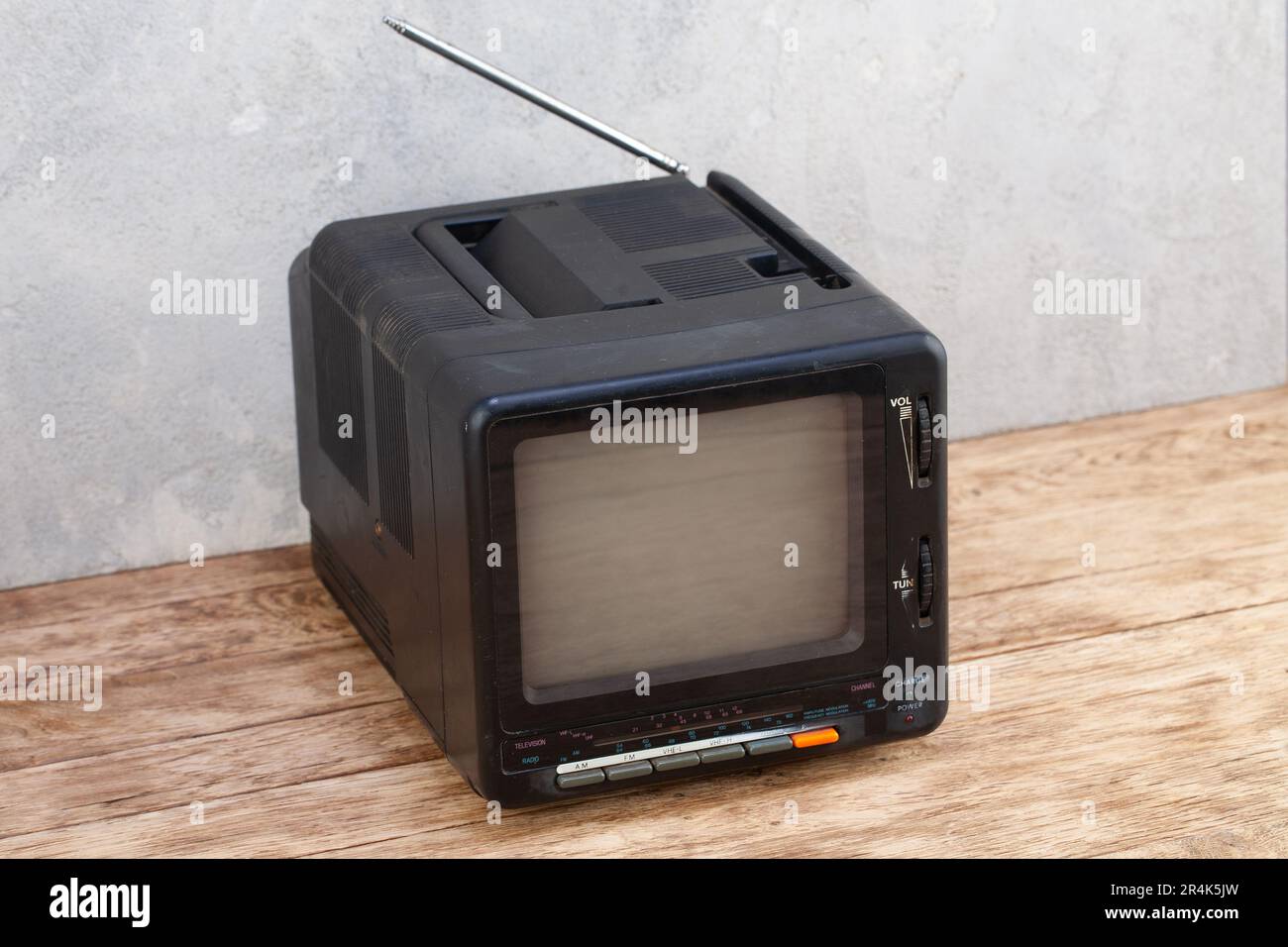 Vintage retro analog small TV set stand on wooden floor front grey ...