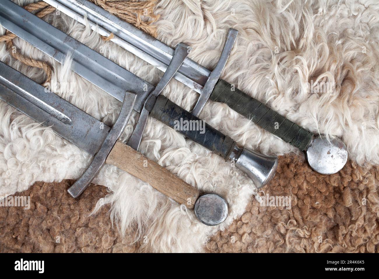 Medieval swords on sheep fur background Stock Photo - Alamy