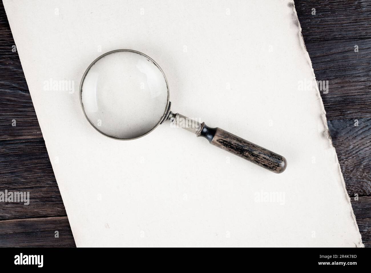 Antique vintage magnifying glass on paper background Stock Photo - Alamy