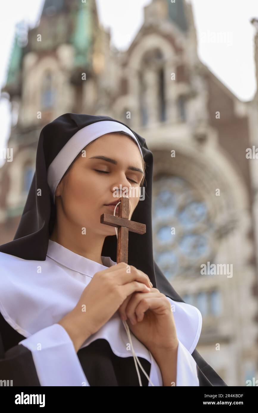 Young nun with Christian cross near cathedral outdoors Stock Photo - Alamy