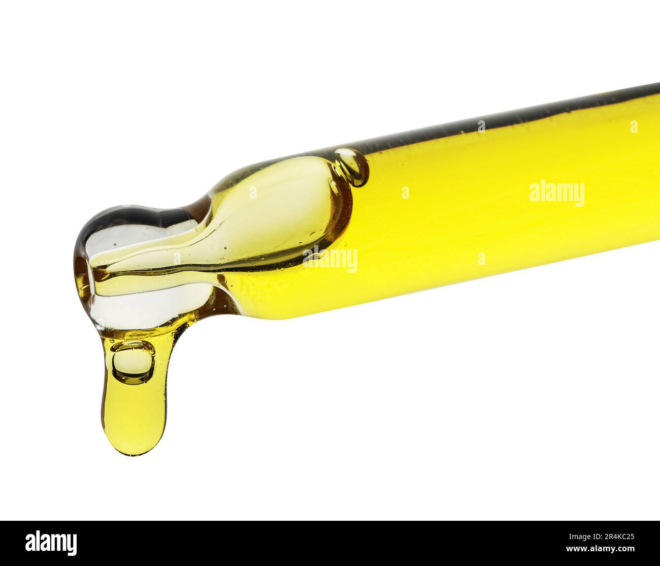 Dripping yellow facial serum from pipette on white background, closeup ...