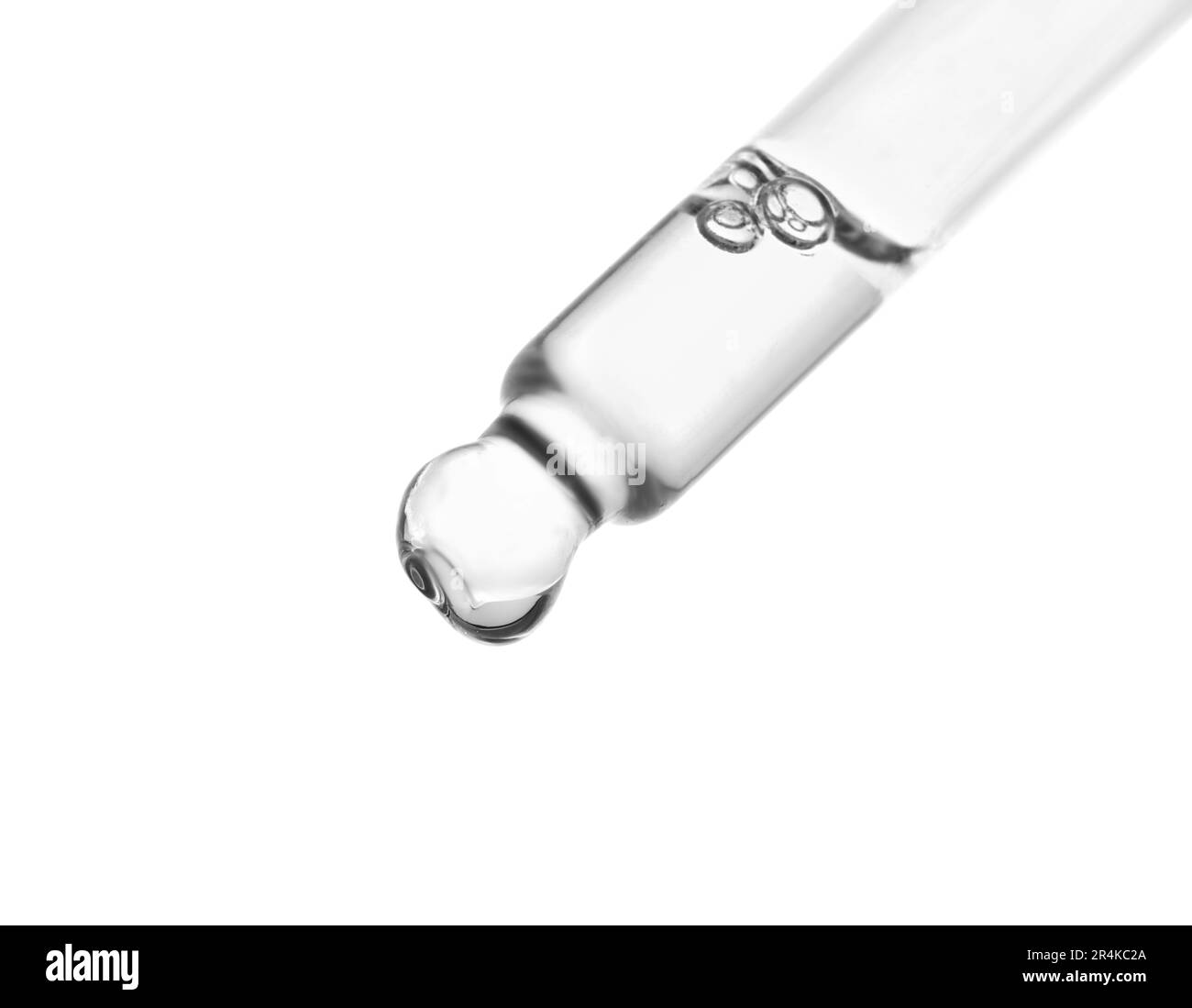 Dripping clear facial serum from pipette on white background, closeup ...