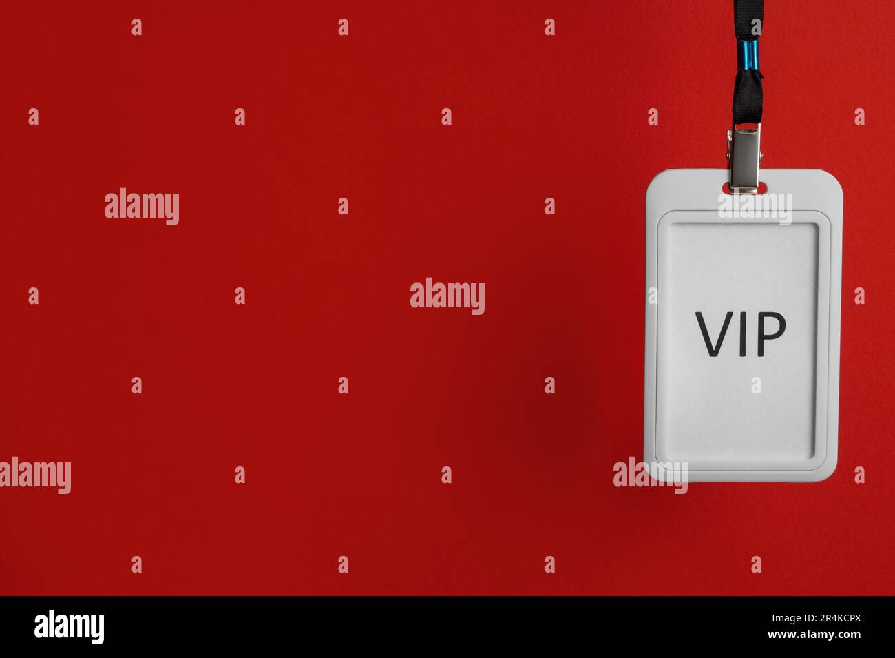 White plastic vip badge hanging on red background, space for text Stock ...