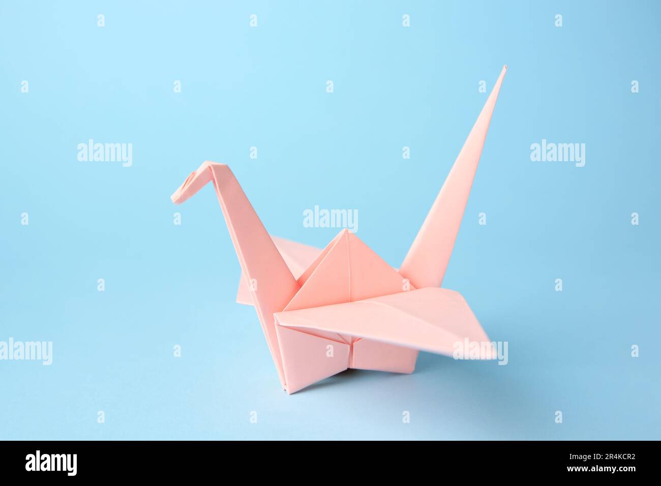 Origami art. Handmade paper crane on light blue background Stock Photo ...