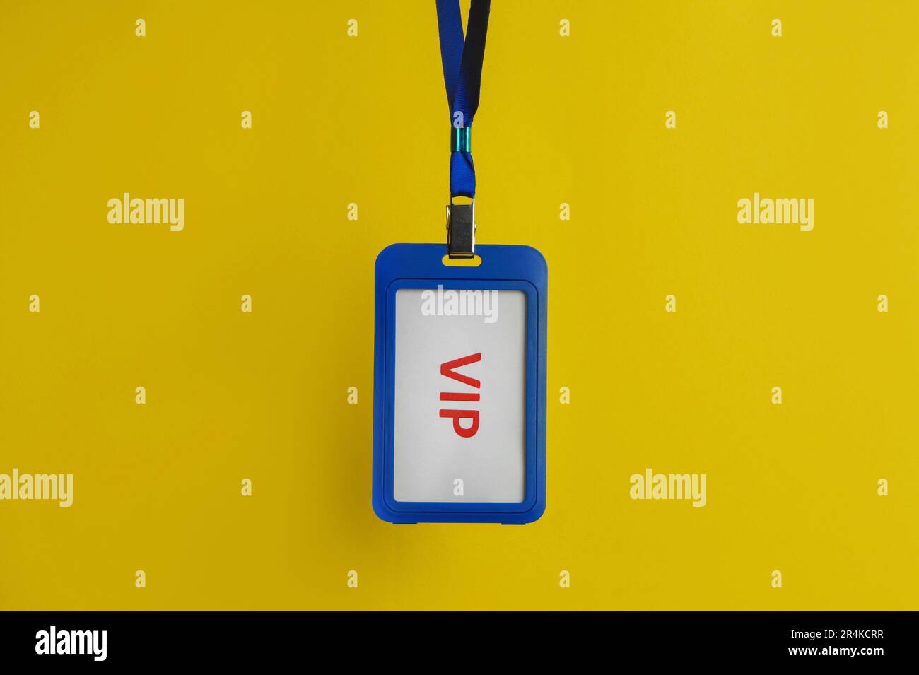 Blue plastic vip badge hanging on yellow background Stock Photo - Alamy